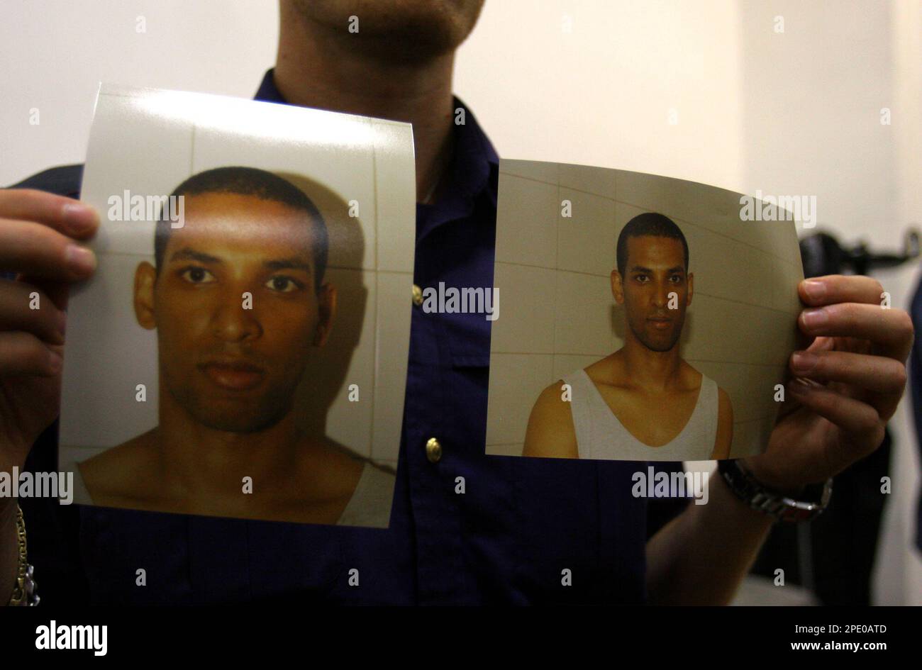 An Italian police officer holds up photos of a man identified as Somali ...