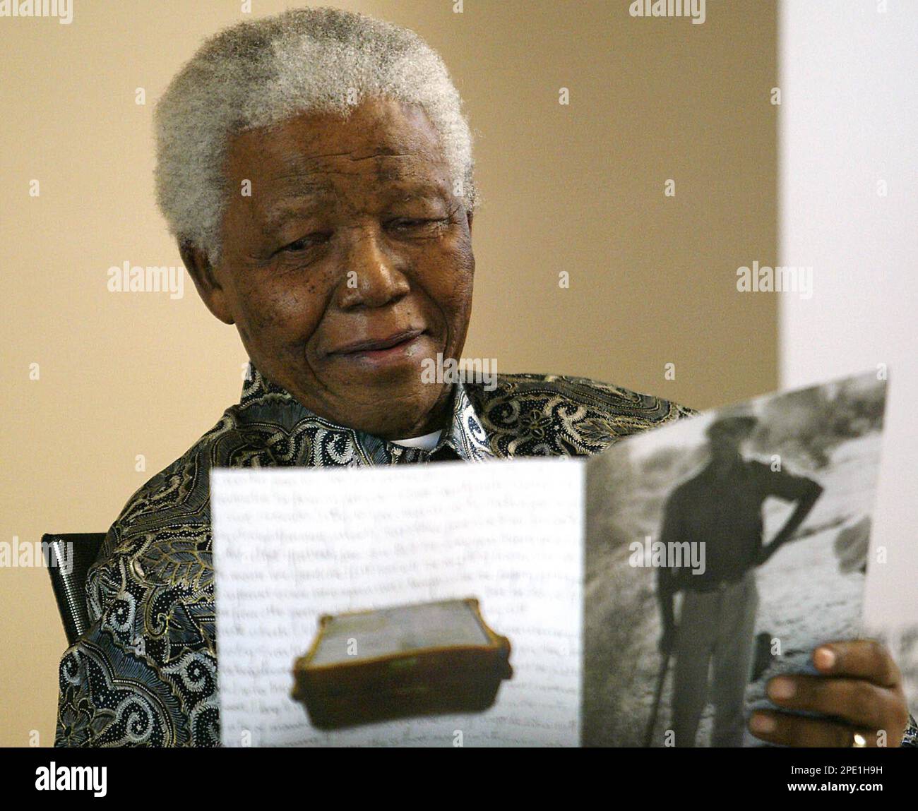 Former South African President Nelson Mandela, studies a program with a ...