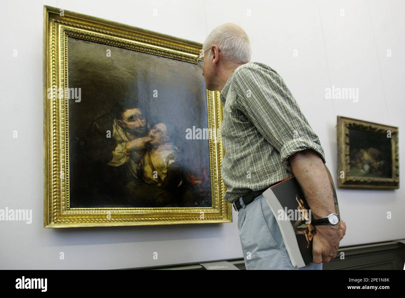 Ein Besucher sieht auf ein Bild in der Ausstellung mit Werken des ...