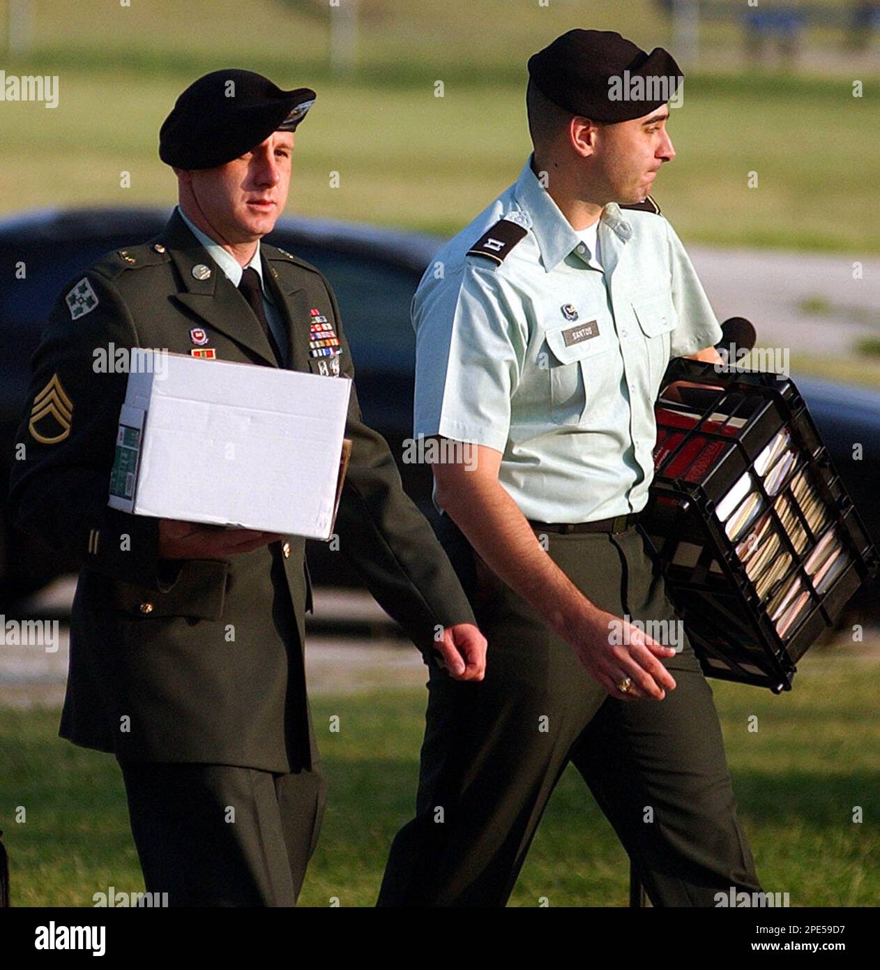 Carrying boxes of documents, U.S. Army Staff Sgt. Shane Werst, left ...