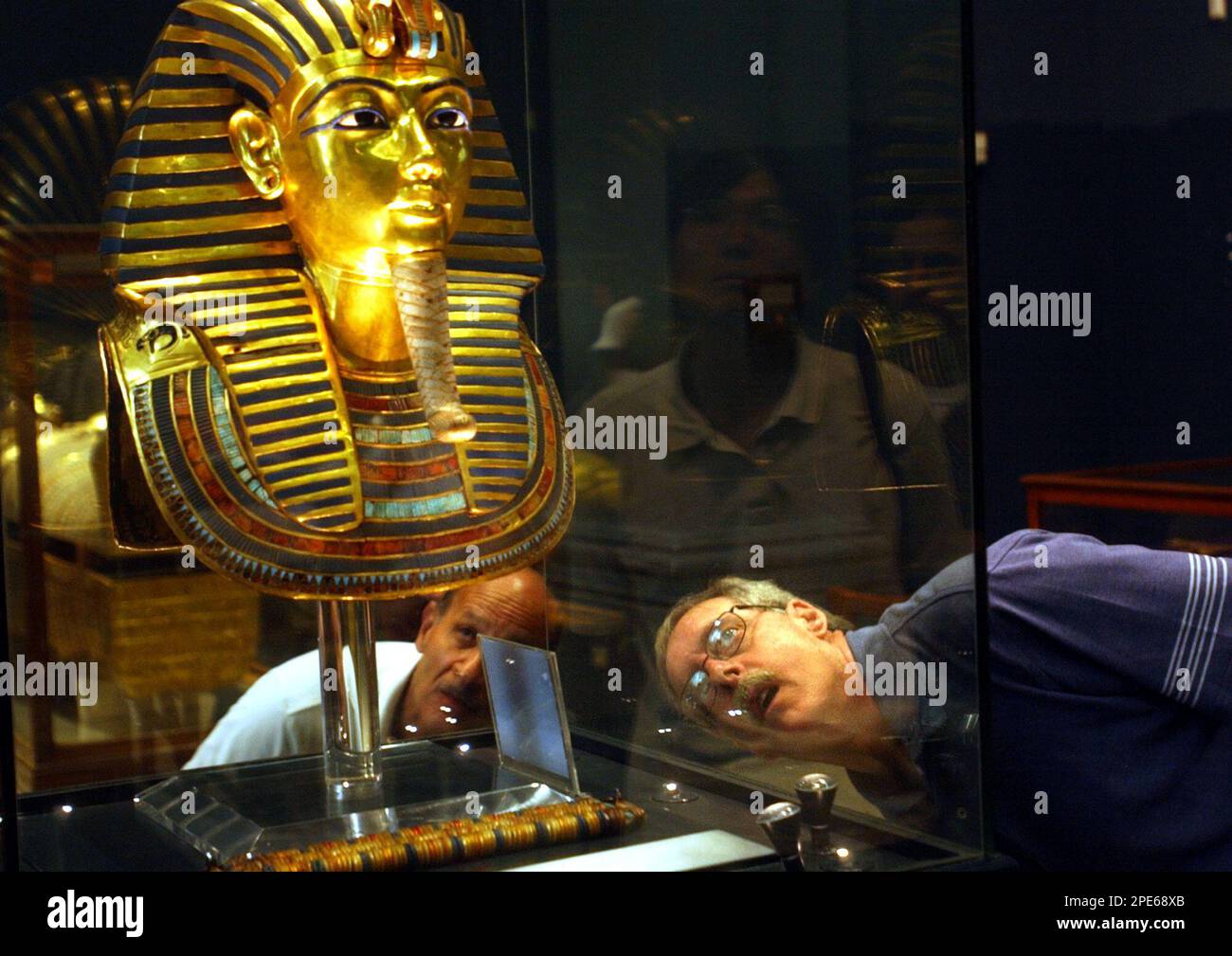 Tourists look to the gold mask of King Tutankhamun at the Egyptian ...
