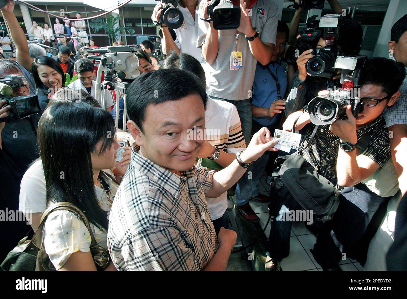 Thailand's Prime Minister Thaksin Shinawatra shows off his voter ...