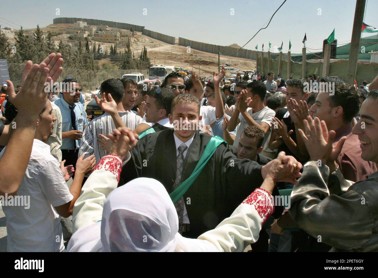 Back dropped by an eight-meter-high cement wall, part of Israel's ...