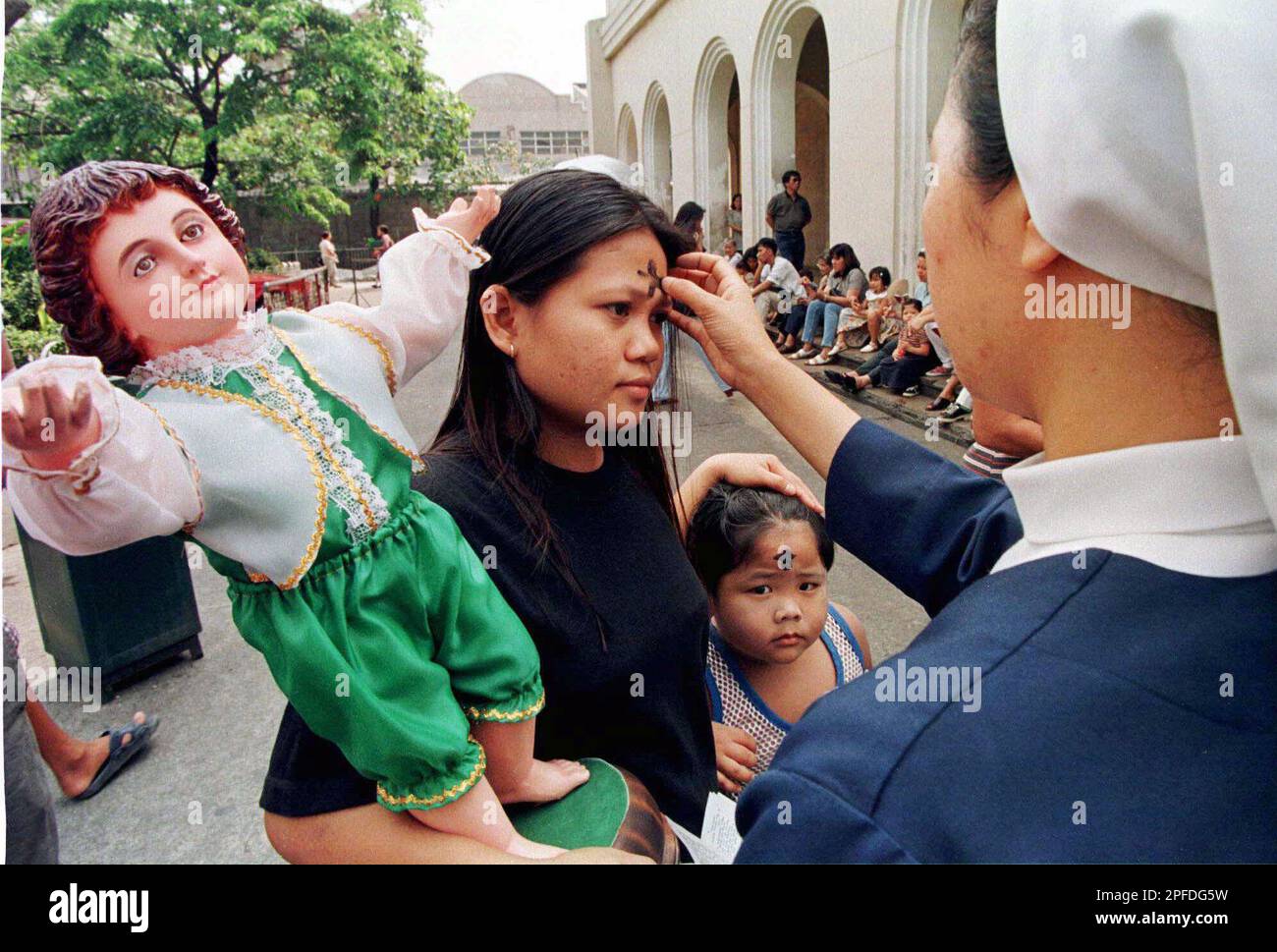 A Roman Catholic nun applies outside a church at suburban Baclaran a ...