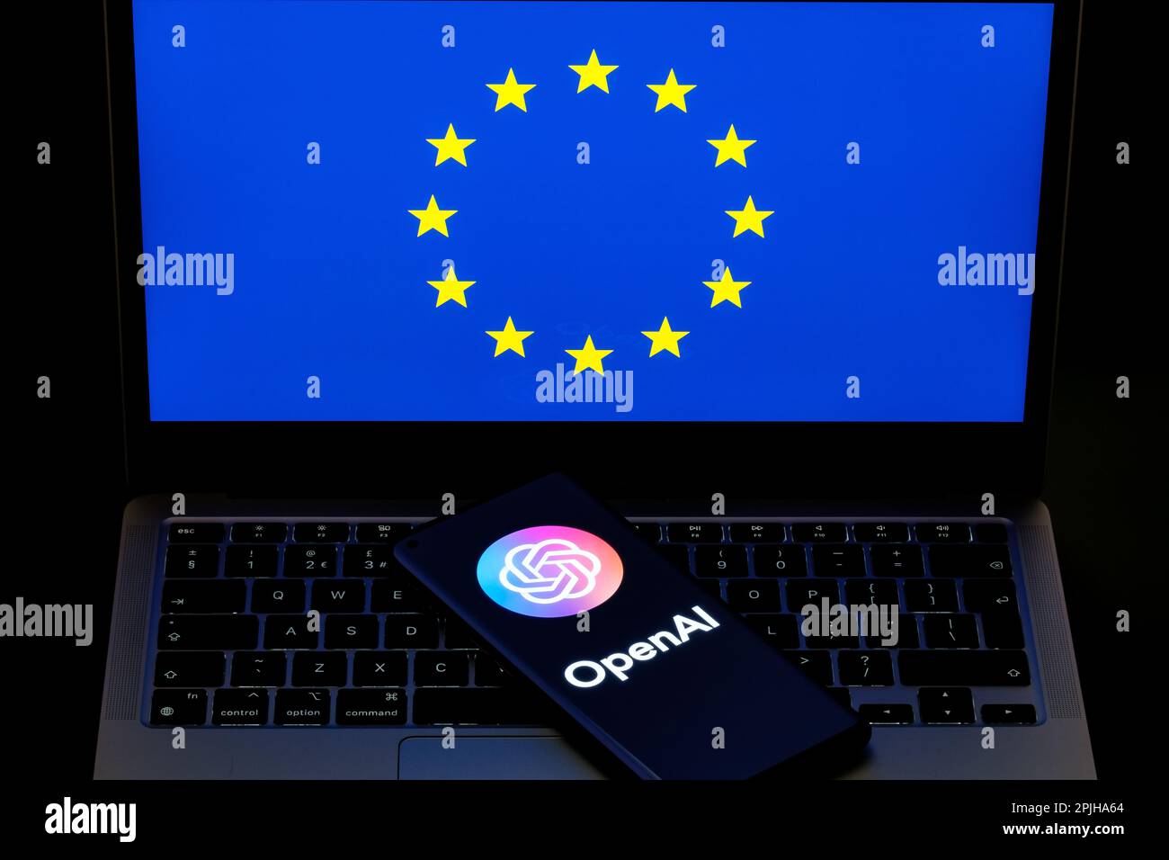 Logo OpenAI visto su smartphone e bandiera dell'UE sul laptop. Concetto per la regolamentazione ...