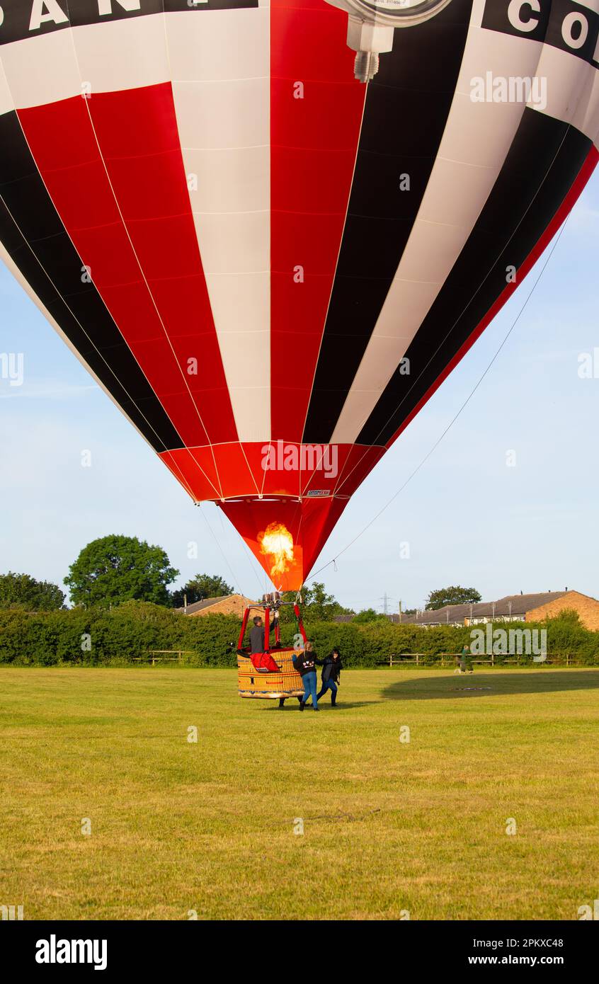 La gente tira lungo un pallone gonfiato ad aria calda in modo che ...