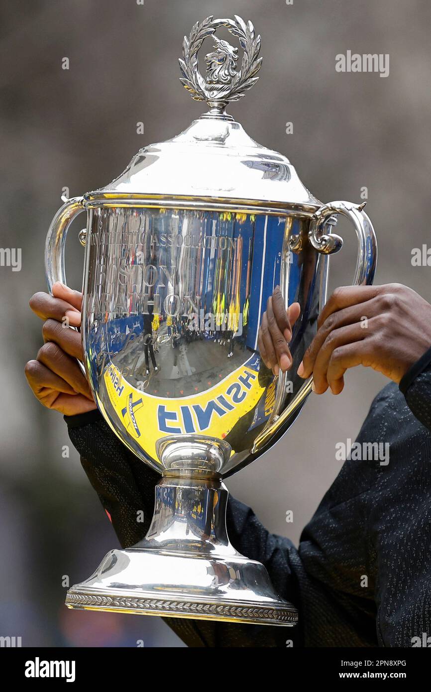 The Boston Marathon trophy is held by Evans Chebet of Kenya after he ...