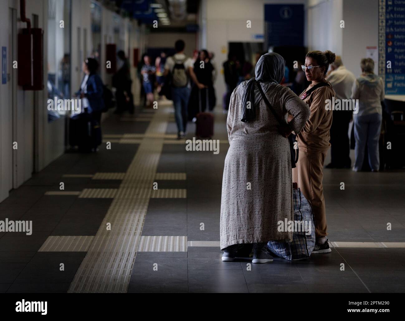 Several travelers with suitcases waiting for the departure of their bus ...