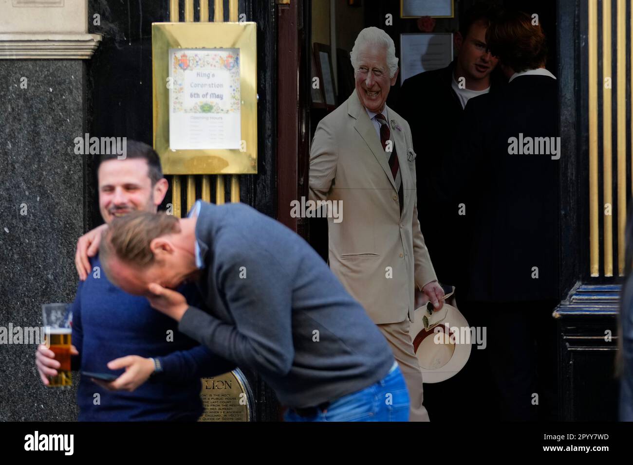 People laugh as a cardboard cut out of Britain's King Charles III is ...
