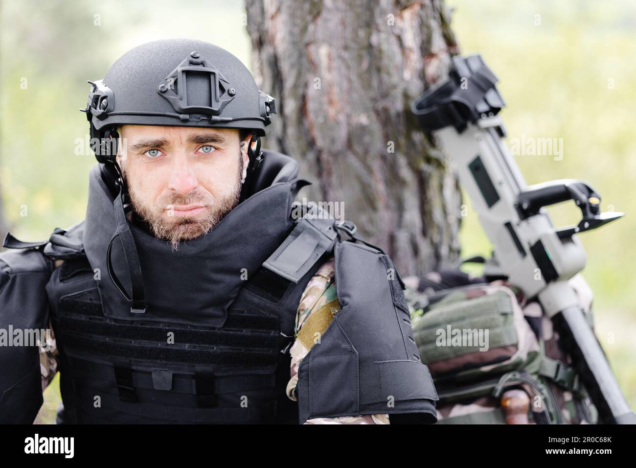 Un uomo in uniforme militare e un giubbotto a prova di proiettile siede ...