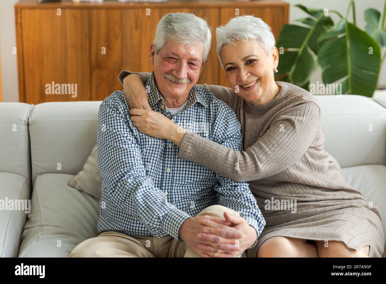 Coppia anziana matura che abbraccia a casa. Marito e moglie di mezza età abbracciando con amore ...