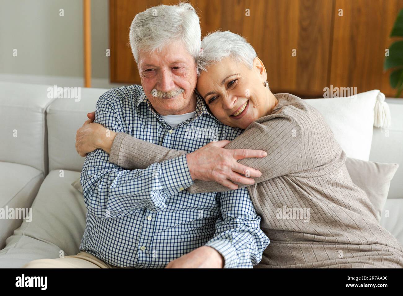 Coppia anziana matura che abbraccia a casa. Marito e moglie di mezza età abbracciando con amore ...