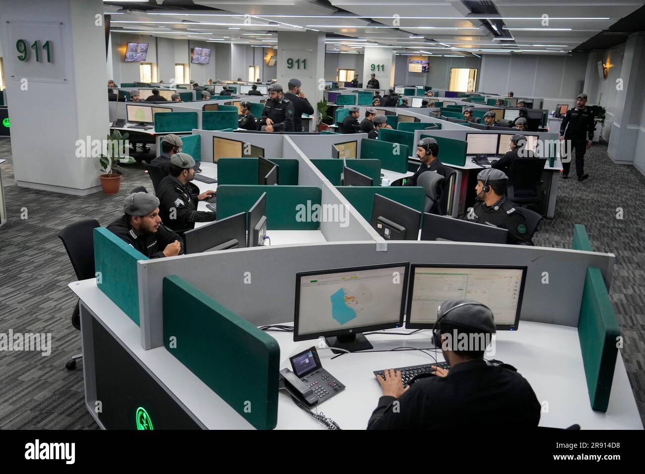 Saudi police officers monitor screens displaying the Grand Mosque, at ...