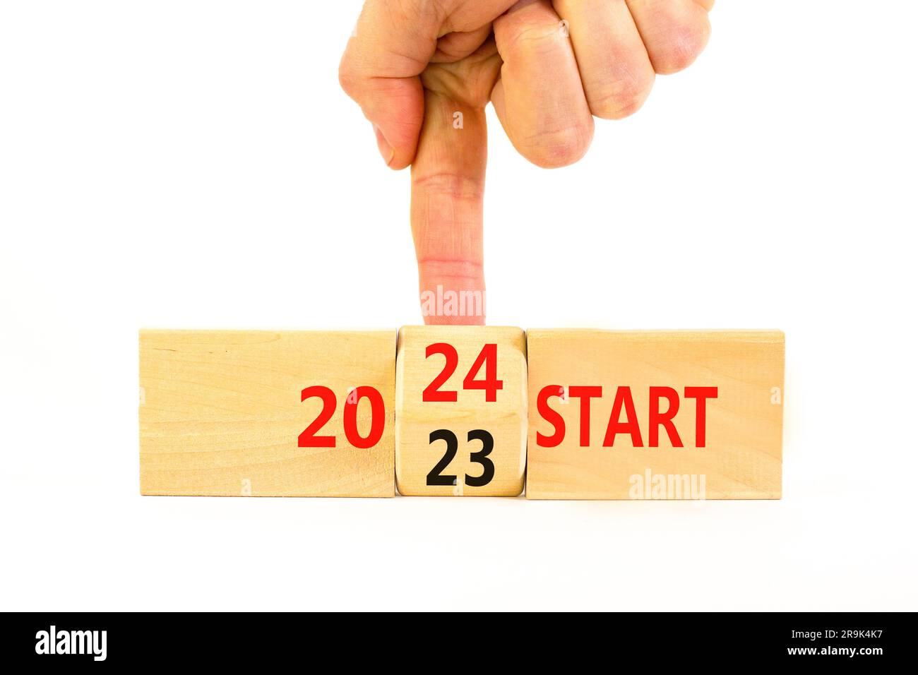simbolo inizio anno 2024. Un uomo d'affari trasforma un cubo di legno e ...