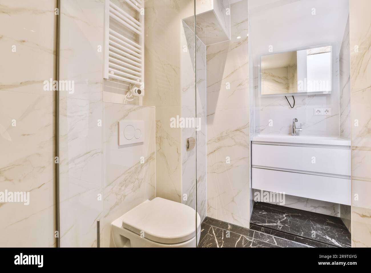 un bagno moderno con pavimento in marmo e pareti bianche, insieme a un ...