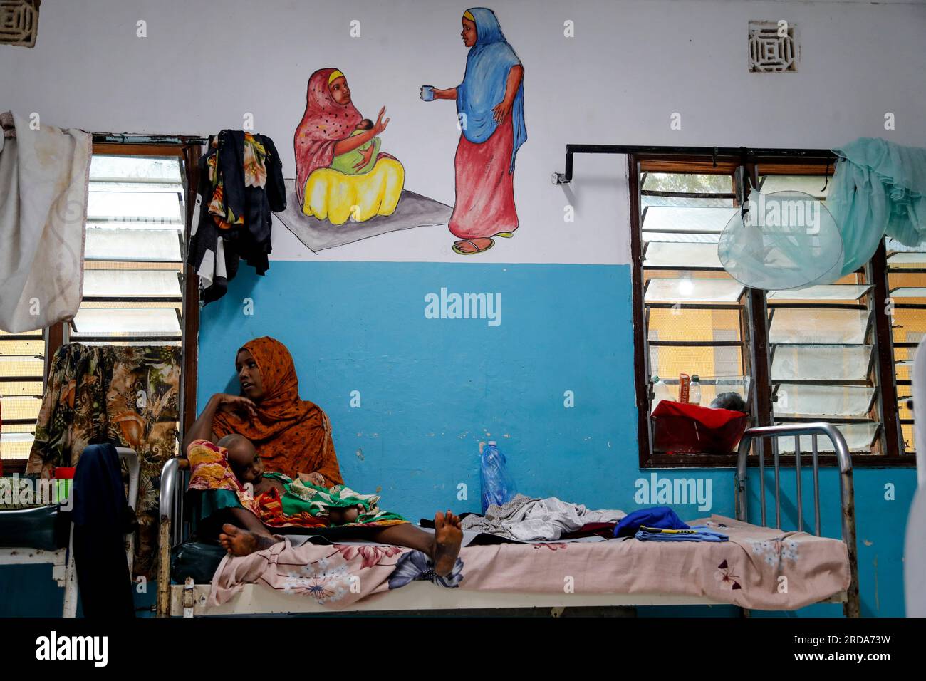 A mother sits with her malnourished child inside the International ...