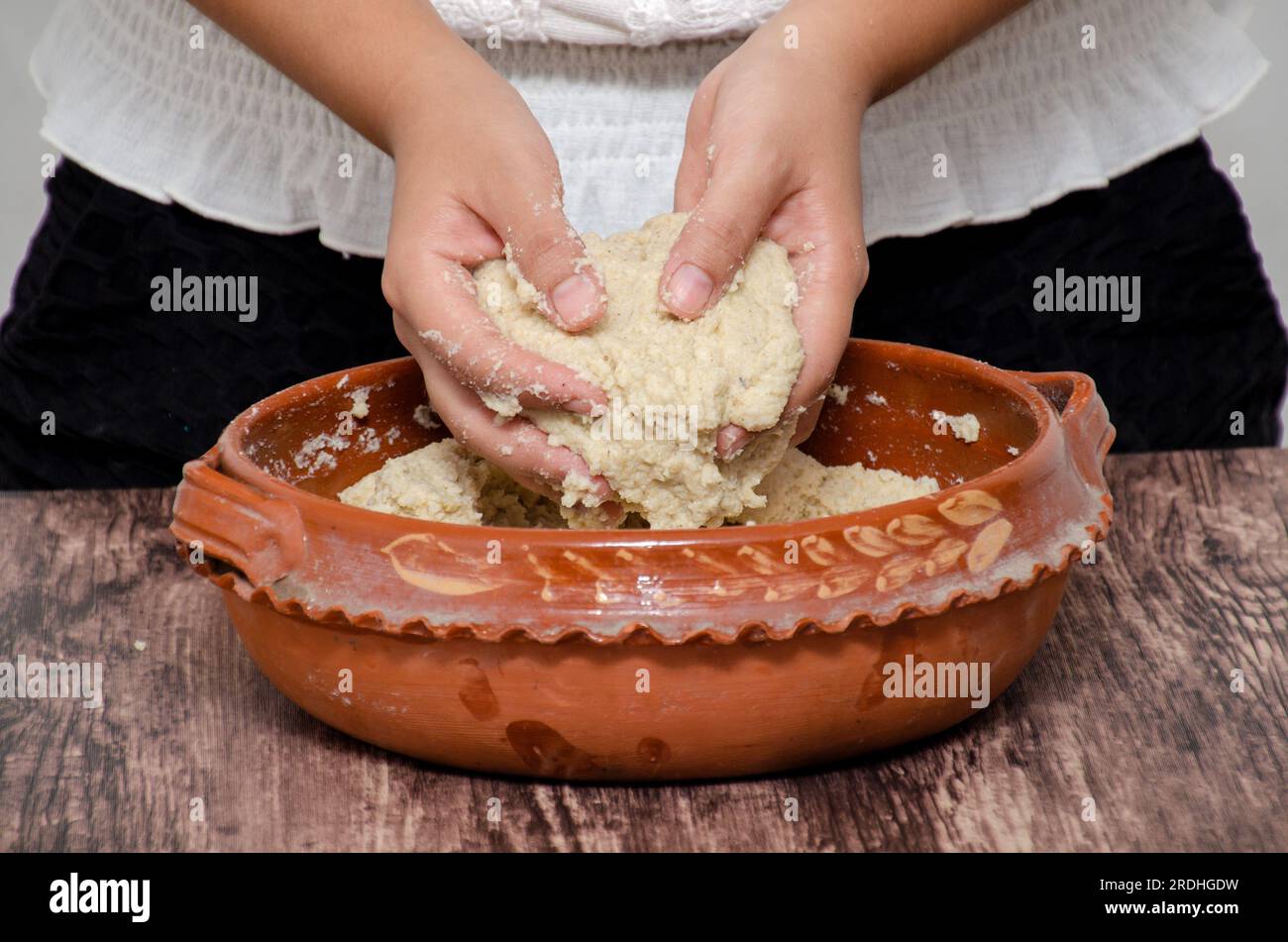 Le mani della donna mescolano la pasta di mais per fare le tortillas ...