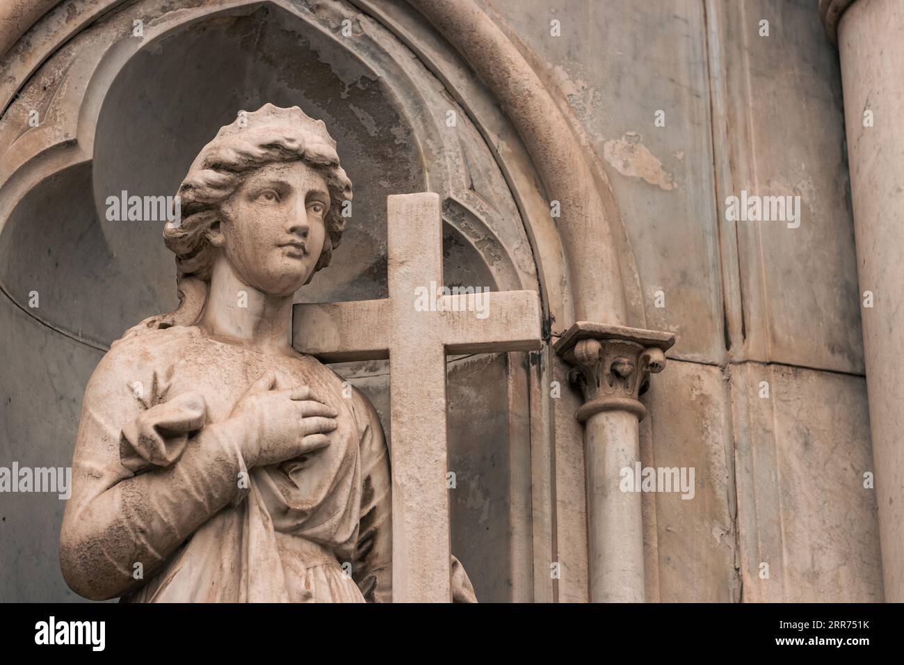 antica statua religiosa in marmo di donna che porta croce cristiana in ...