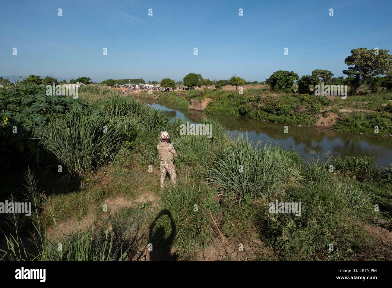 A Dominican Republic soldier stands on the bank of the Massacre River ...