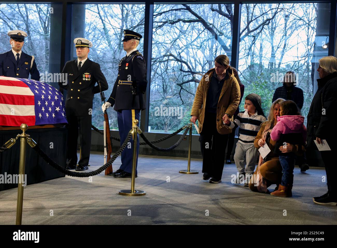 Members of the joint services military honor guard stand by the casket bearing the remains of ...