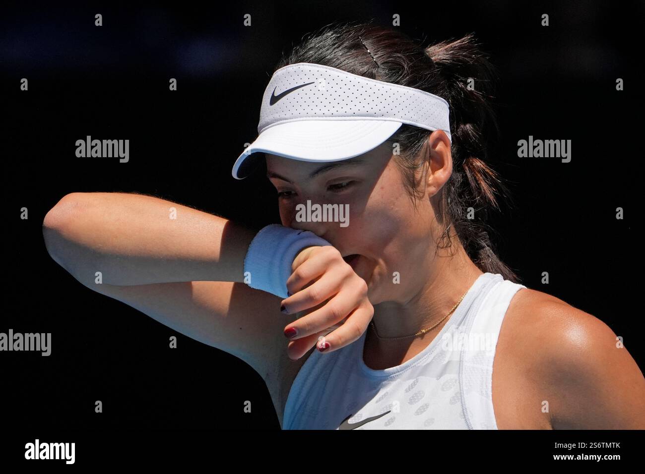 Emma Raducanu of Britain wipes the sweat from her face during her third ...