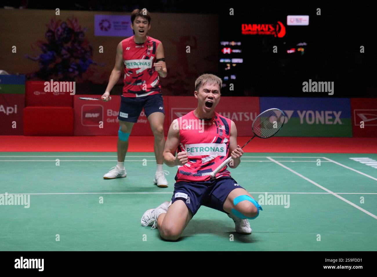 Man Wei Chong, left, and Kai Wun Tee of Malaysia celebrate after defeating Fajar Alfian and ...