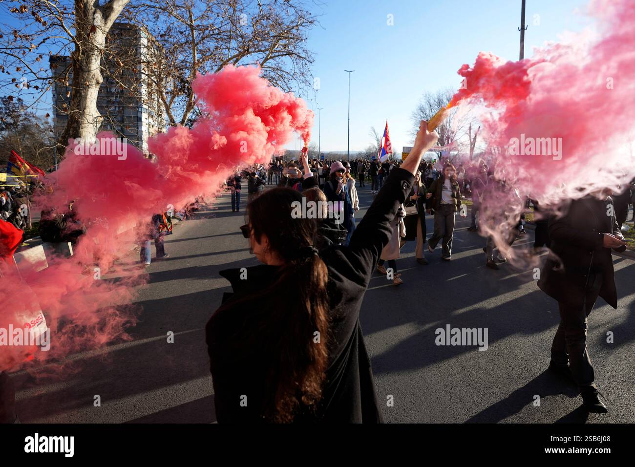 People light up smoke flares as they march during a protest over the ...