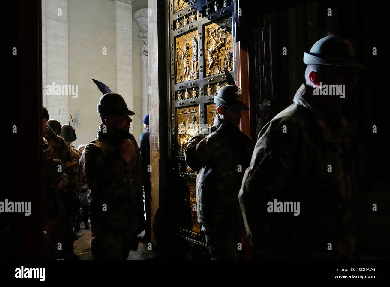 Members of the military walk through St. Peter Basilica's holy door, on ...