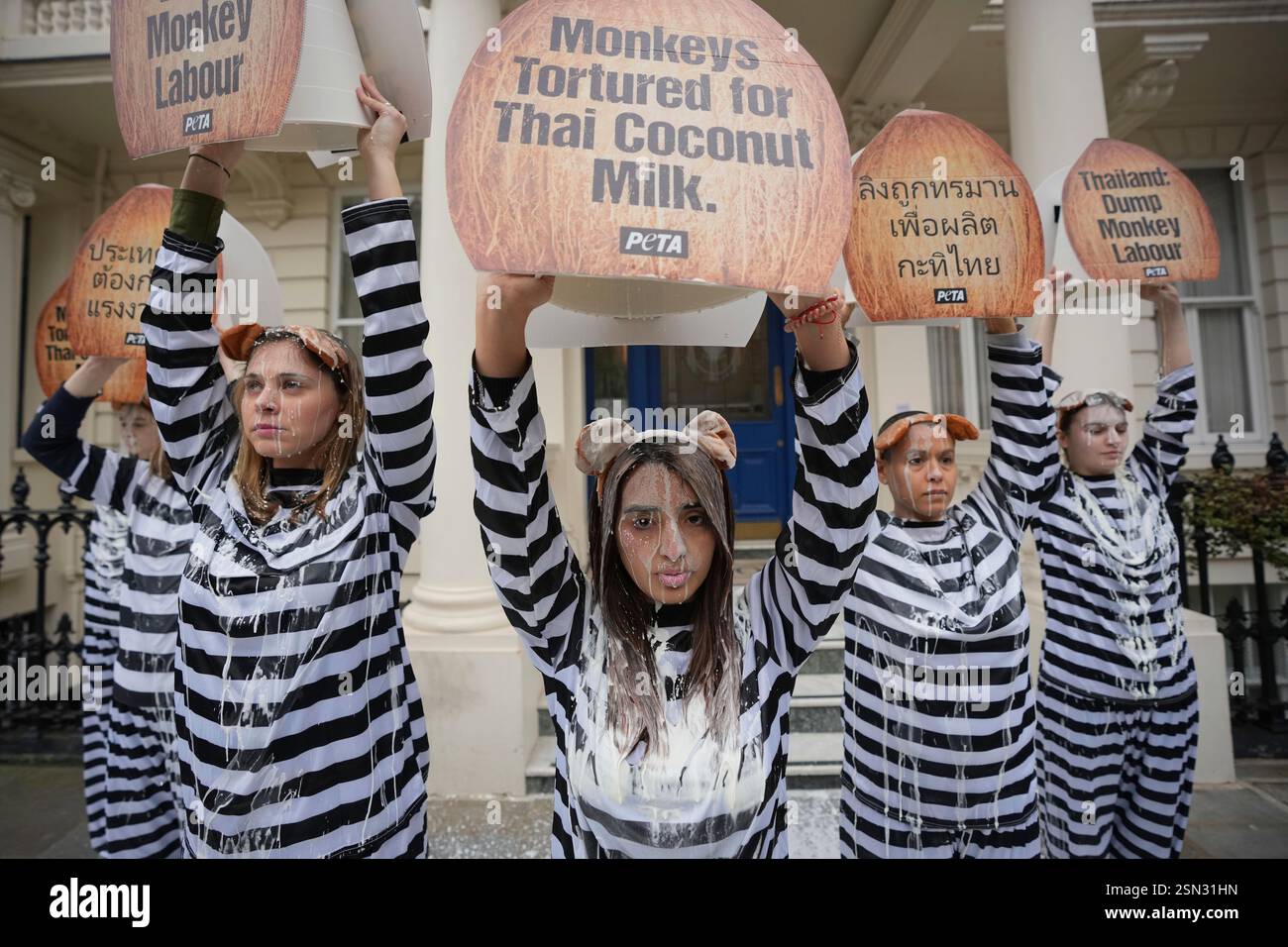 A troop of PETA "monkeys" in prisoner garb dump buckets full of ...