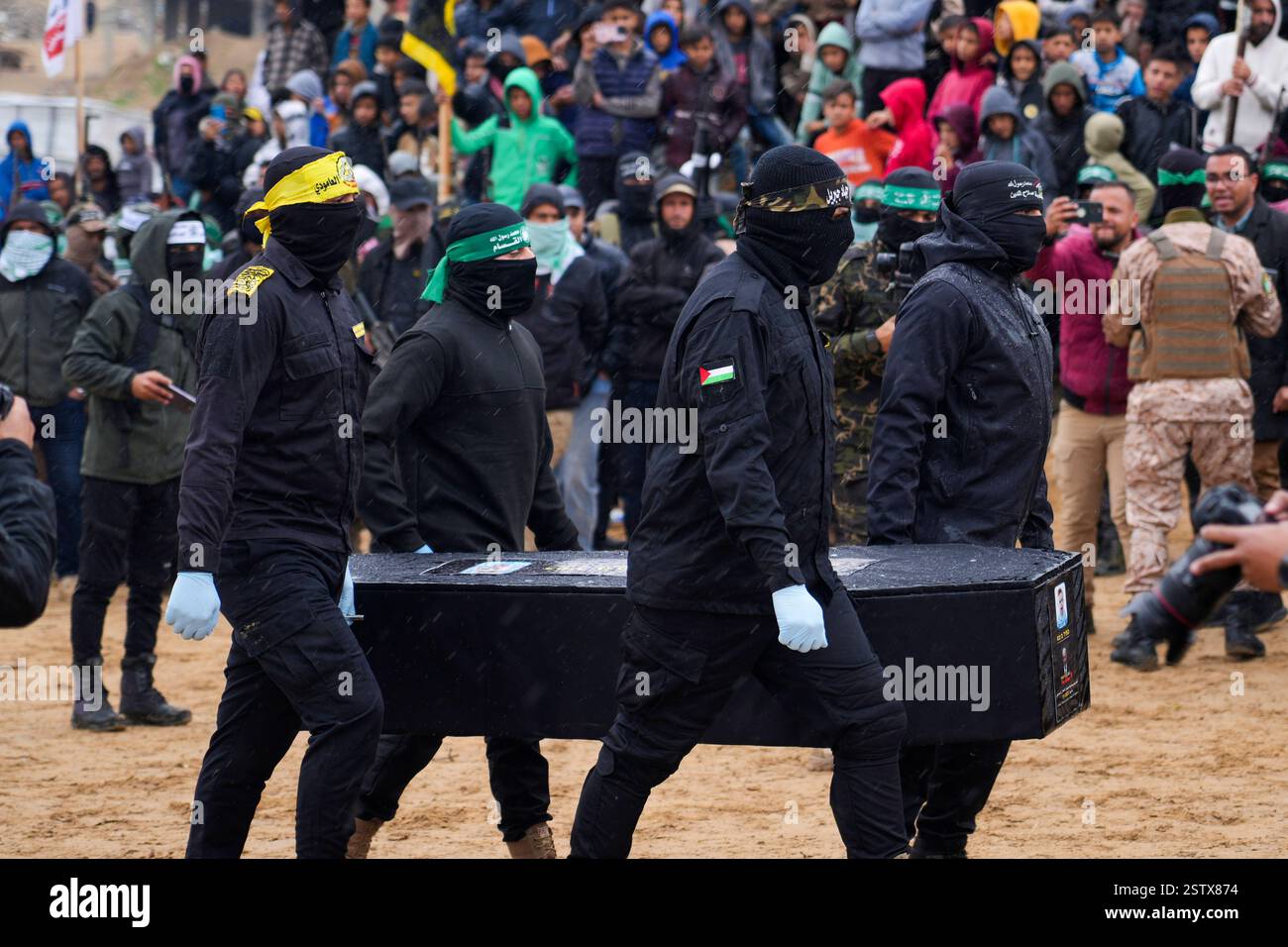 Palestinian fighters carry a coffin containing the body of Ariel Bibas ...