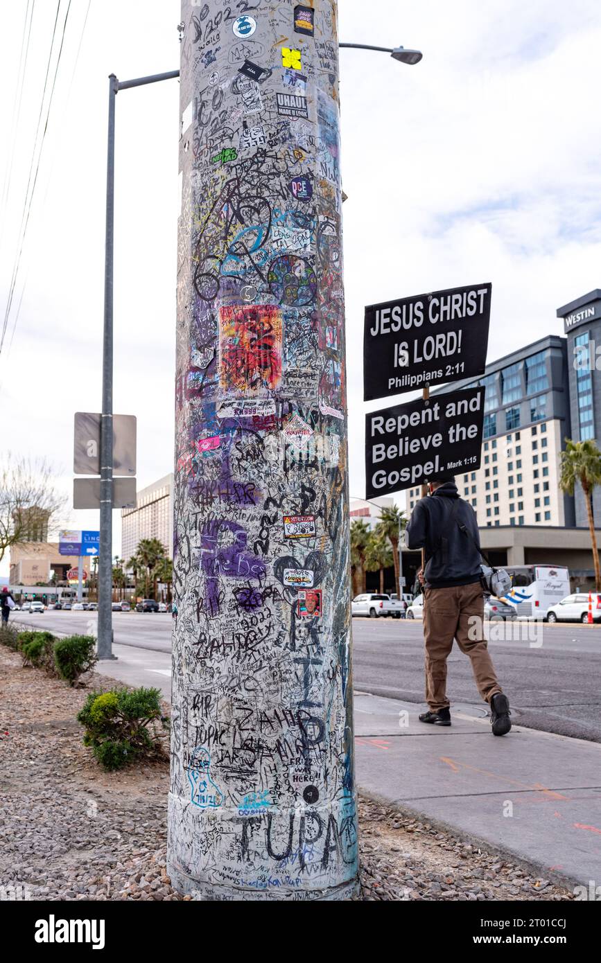 Il predicatore di strada che porta un cartello di grandi dimensioni passa davanti a un memoriale ...