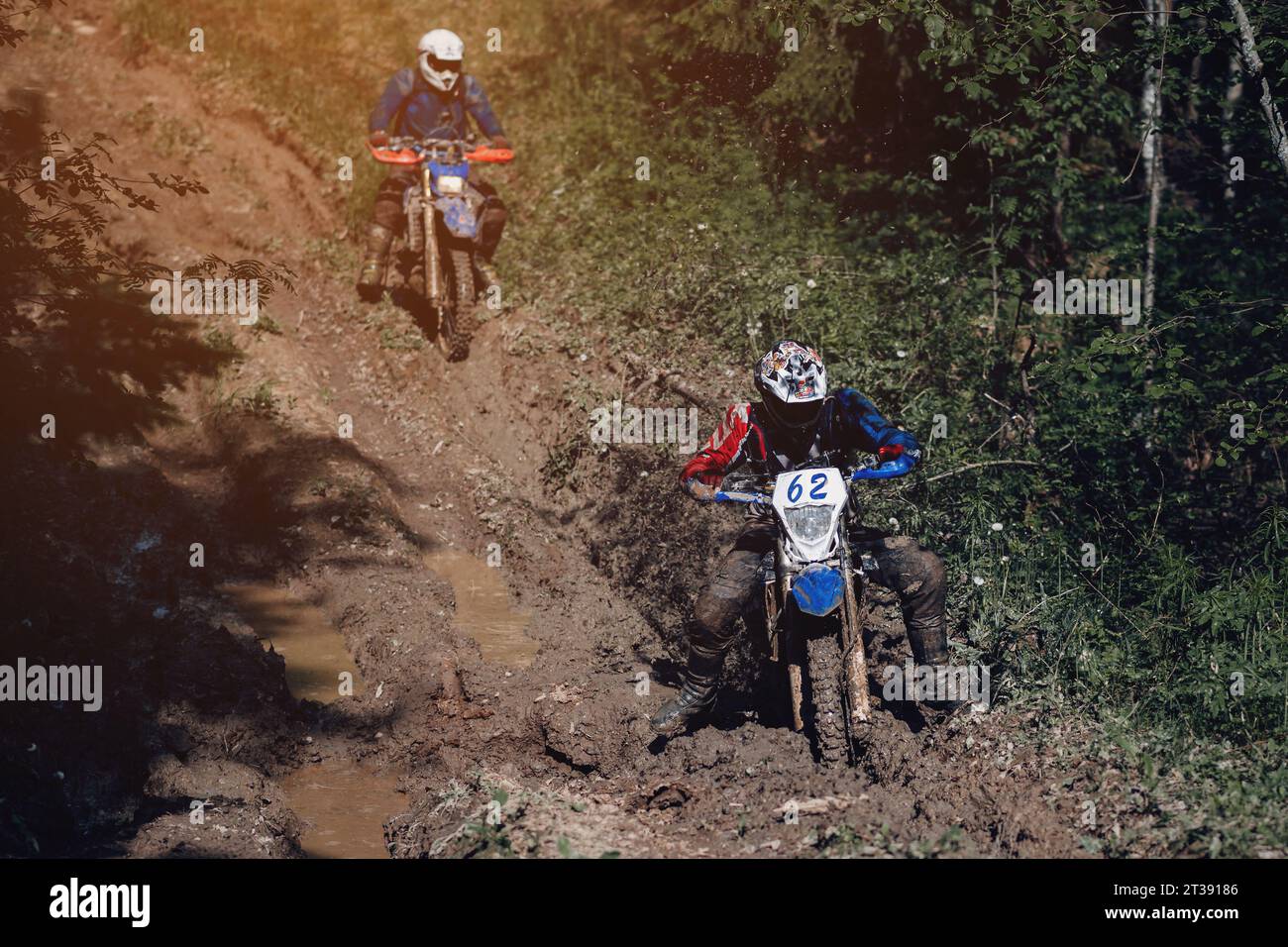 il pilota motociclistico su una pista da enduro su una strada fangosa ...