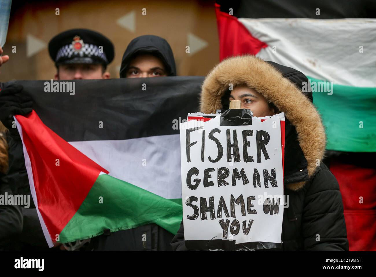 Un attivista tiene un cartello con la scritta "Fisher German Shame on ...