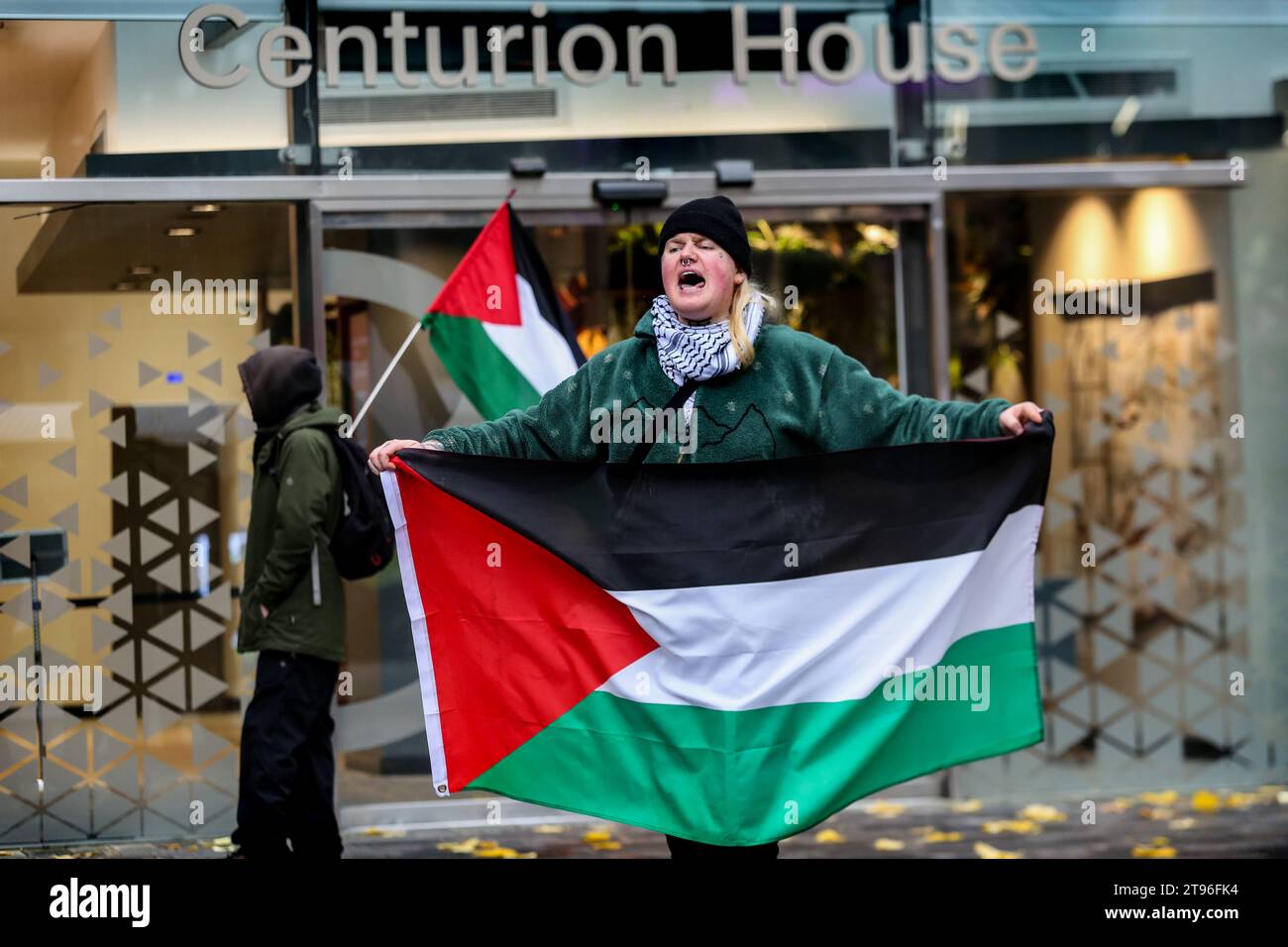 Un attivista canta slogan mentre tiene una bandiera palestinese fuori ...