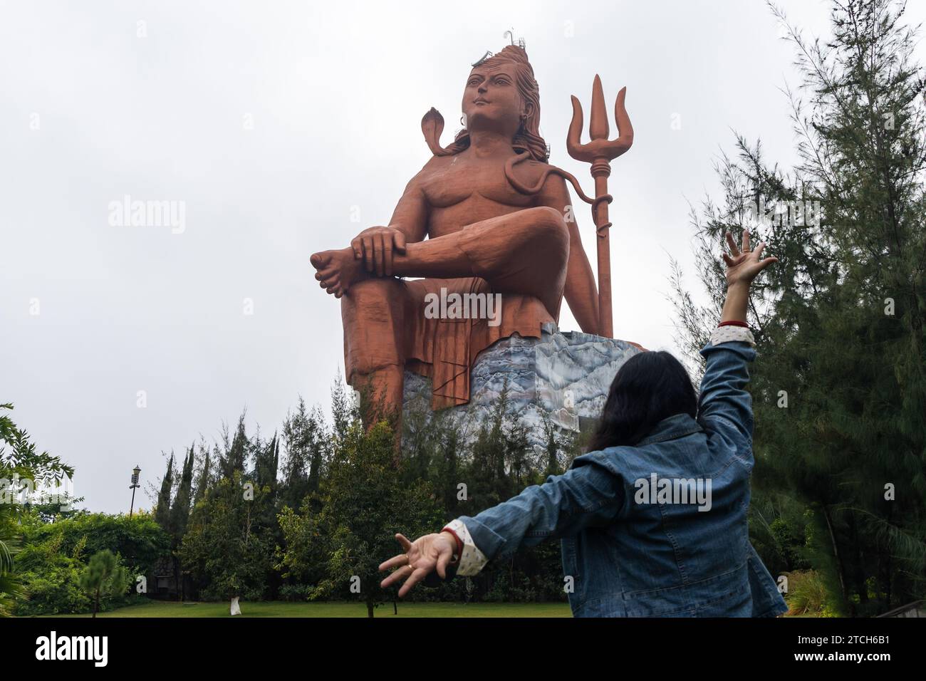 Devoto pregando il dio indù signore shiva, un'enorme statua isolata al mattino viene scattata ...