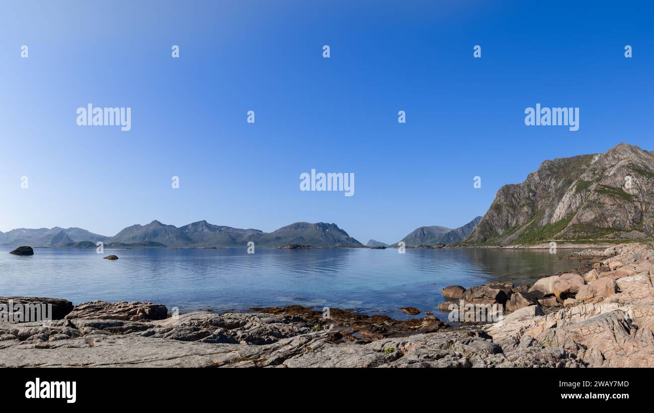 La costa frastagliata del Lofoten si snoda sotto un cielo limpido, con ...