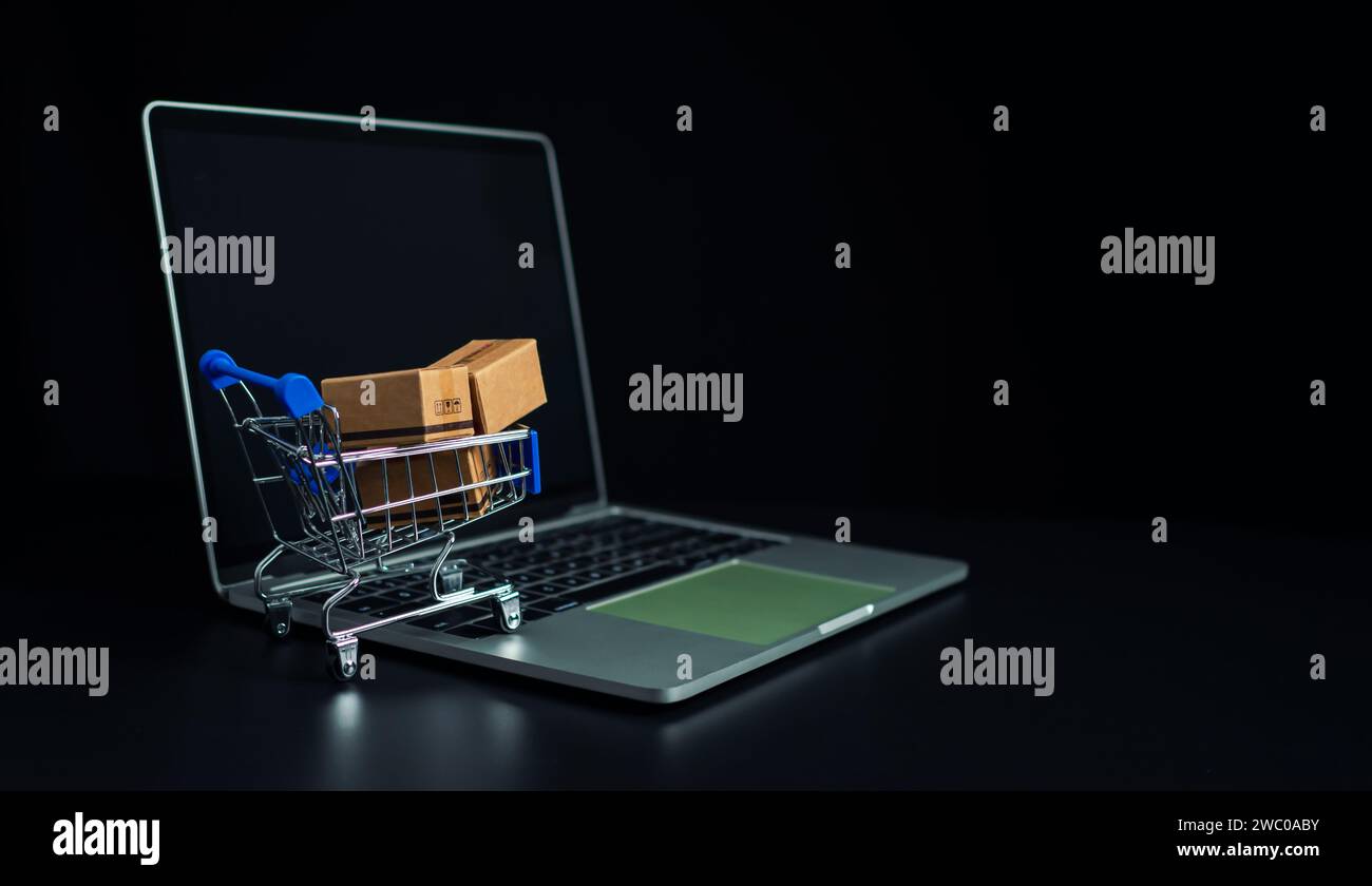 Scatole in un'auto della spesa sulla tastiera di un notebook. Idee ...