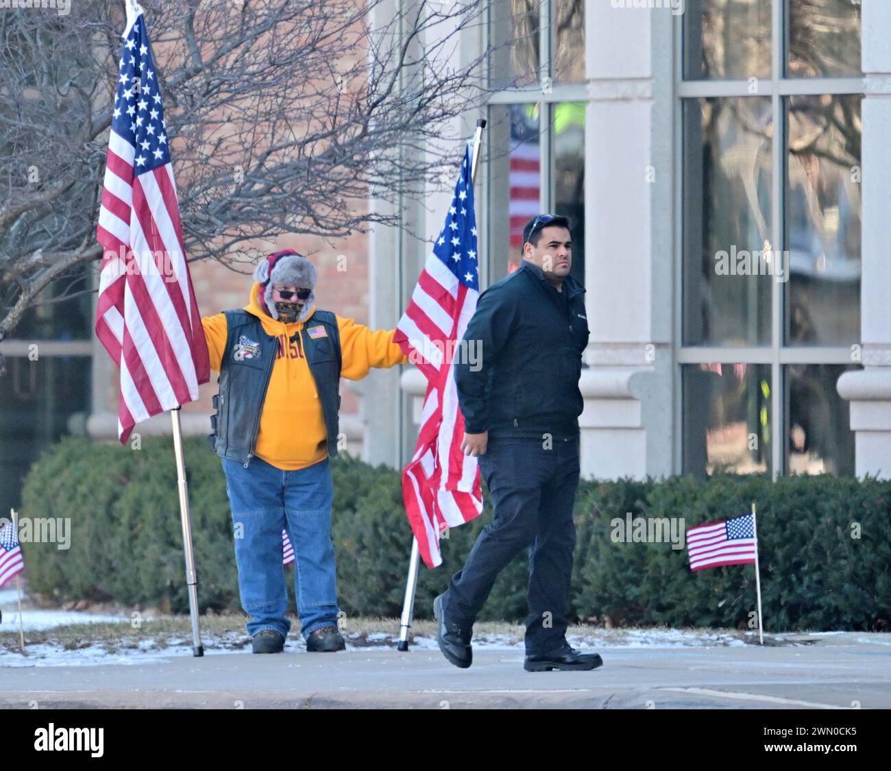 A man holds two American flags outside a memorial service for three ...