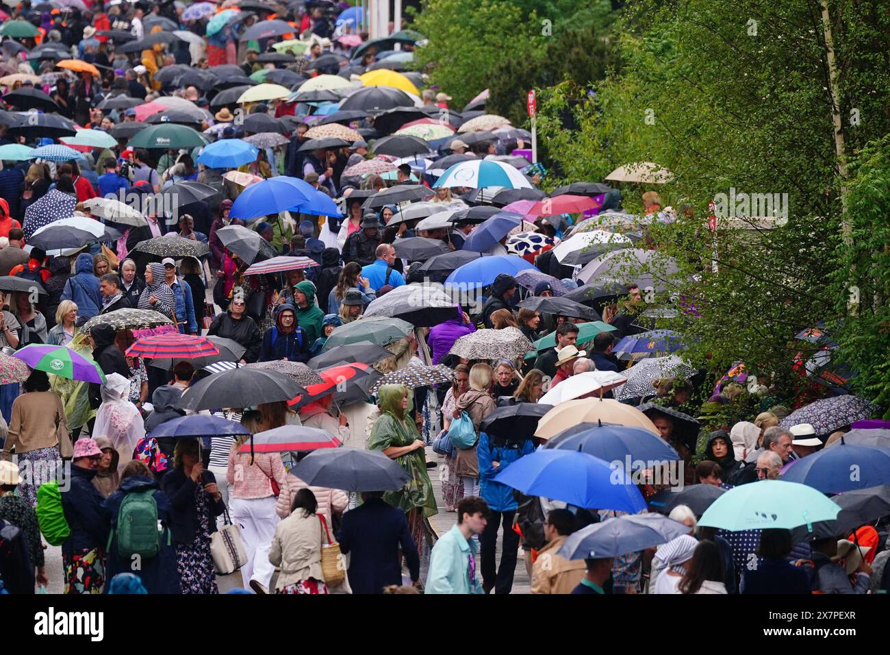 Gli ospiti si riparano sotto gli ombrelli mentre piove durante lo ...