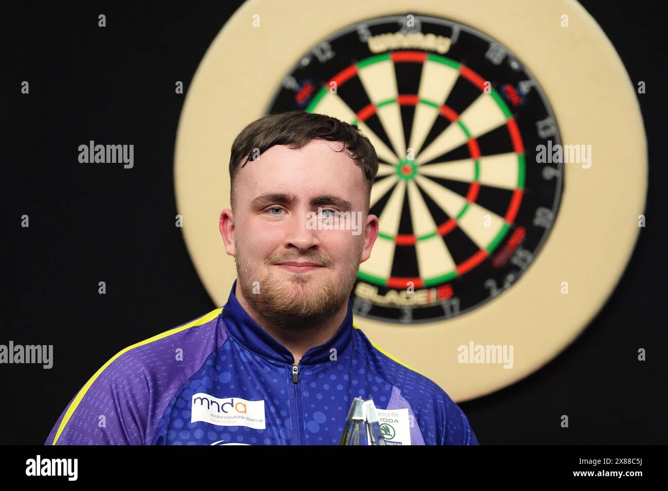 Luke Littler festeggia con il trofeo dopo la vittoria in finale contro ...