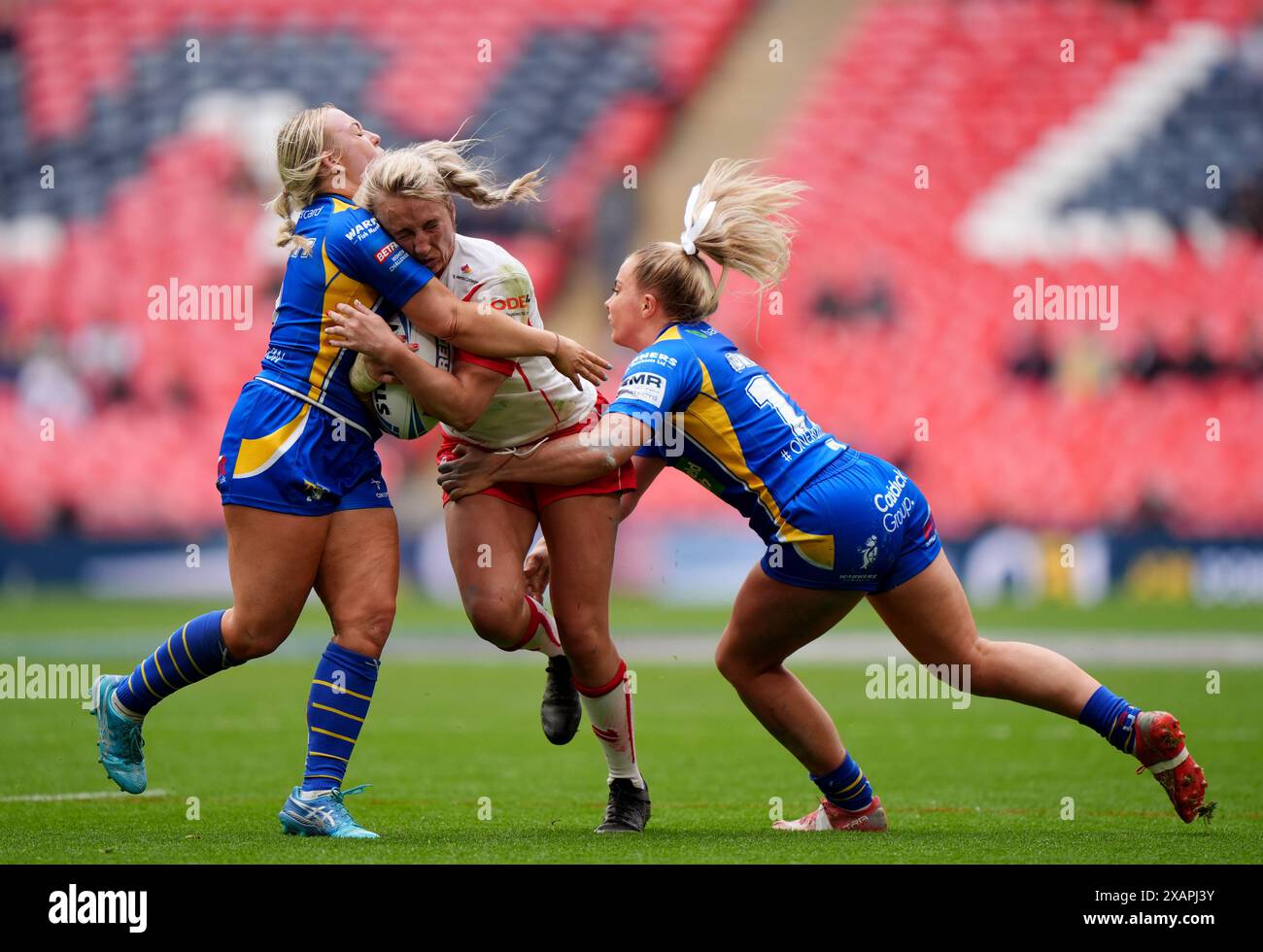 Jodie Cunningham (centro) di St Helens è placcato da Keara Bennett ...