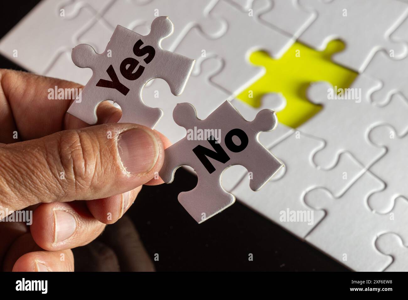 Una persona ha due pezzi di puzzle, uno dei quali dice "sì” e l'altro ...