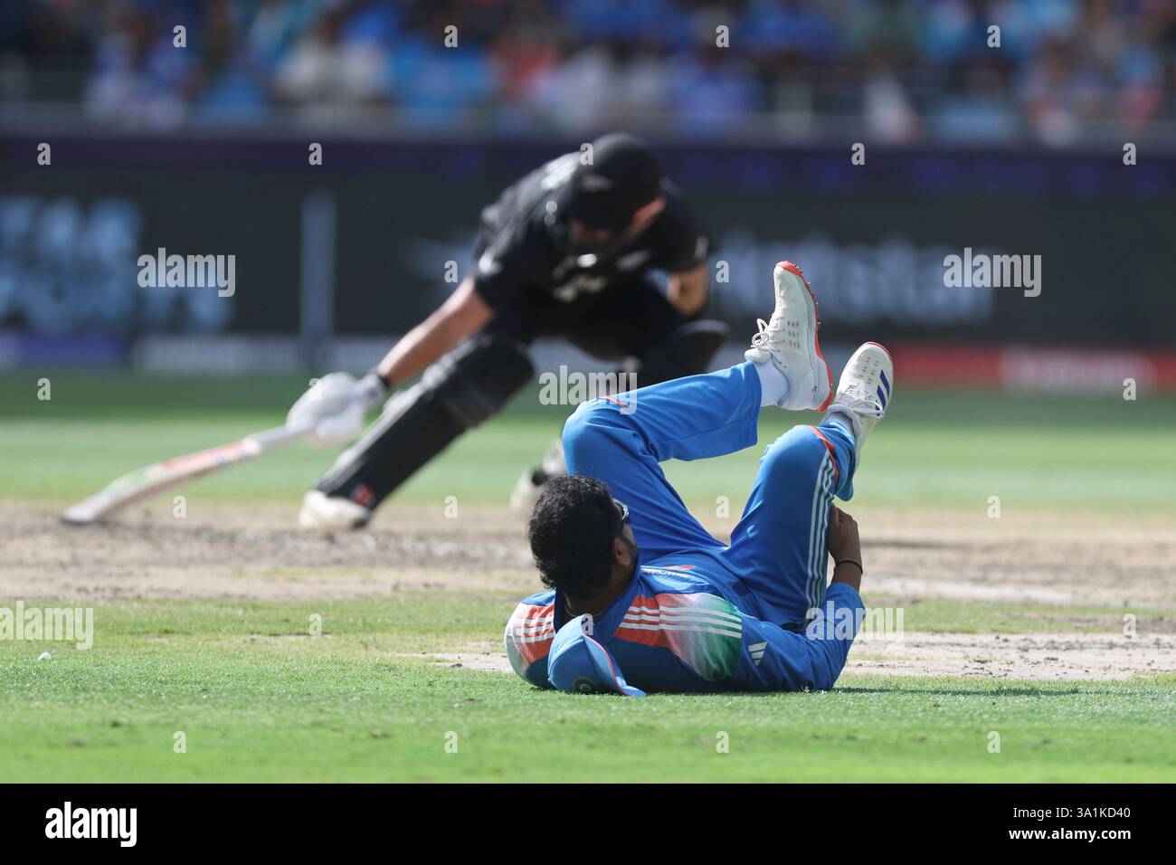 India's captain Rohit Sharma falls after failing to take the catch of New Zealand's Daryl ...