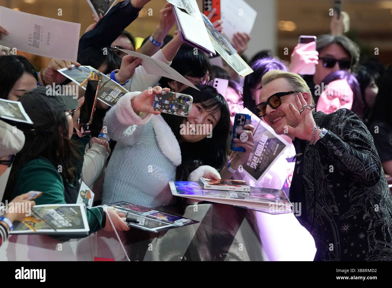 Simon Pegg poses to take photos with a fan during a red carpet event to ...