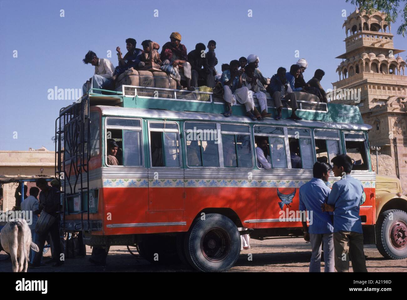 Uomini a cavallo sul tetto di un autobus affollato in Jaisalmer ...