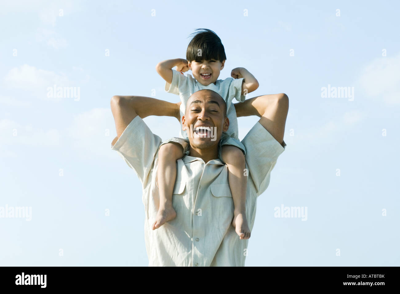 Uomo figlio che porta sulle spalle, entrambi sorridente in telecamera ...