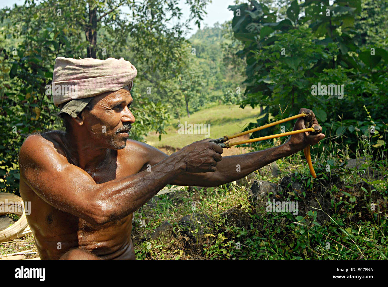 Uomo tribale di Kokna che mira con l'aiuto di colpo di fucile o ...