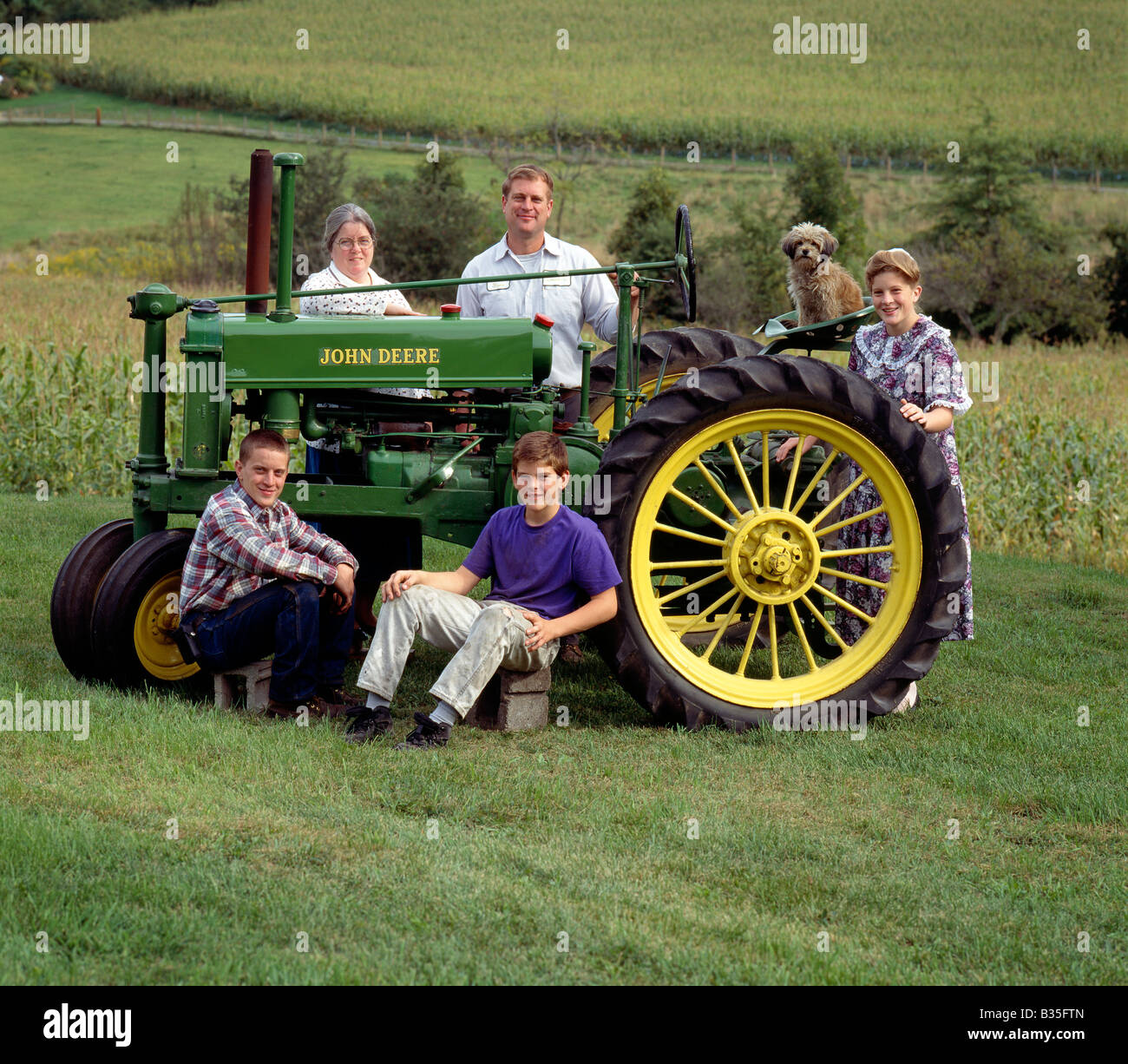 Attrezzature agricole aggiustatore e la sua famiglia posano con un ...