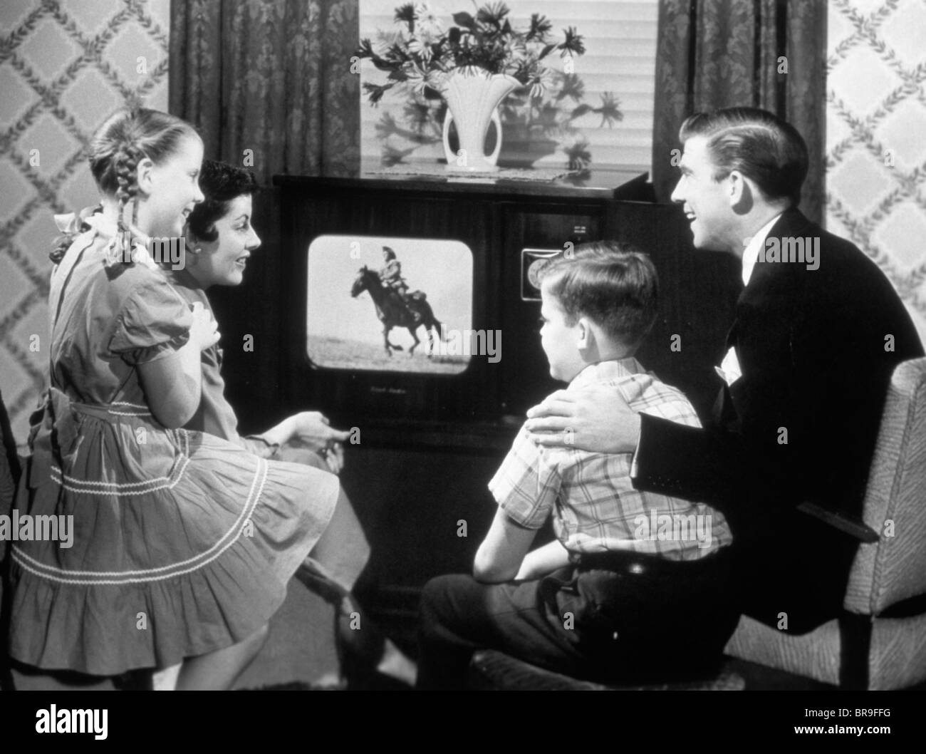 Degli anni Cinquanta la famiglia di quattro guardando la televisione in ...