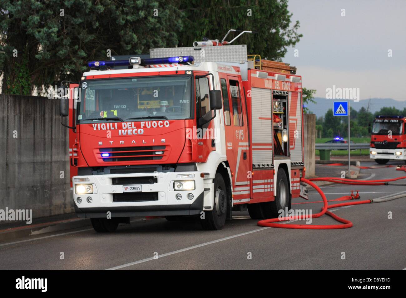 I vigili del fuoco in azione con il camion dei pompieri per estinguere ...